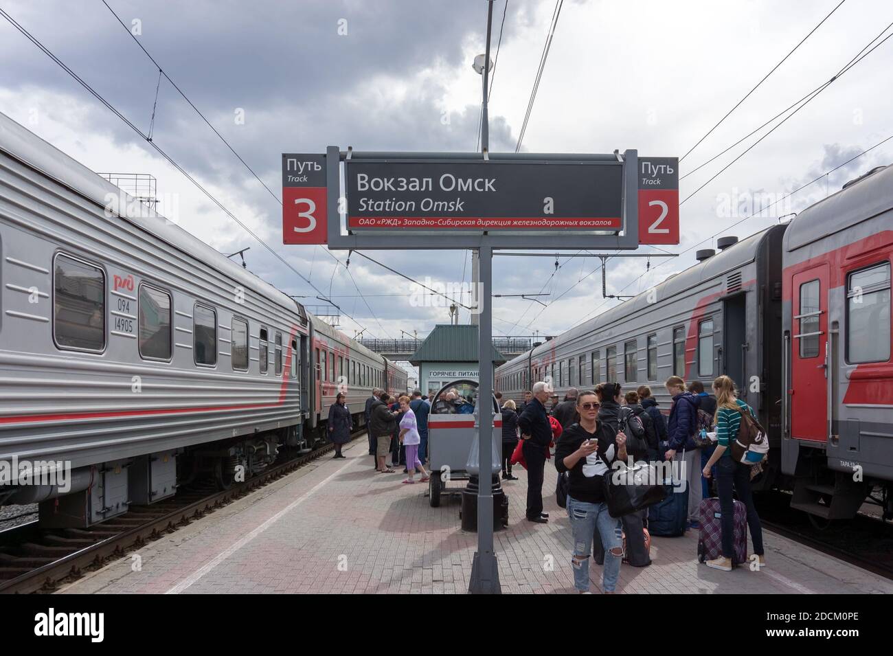 Passengers are resting next to the electronic sign on the platform ...