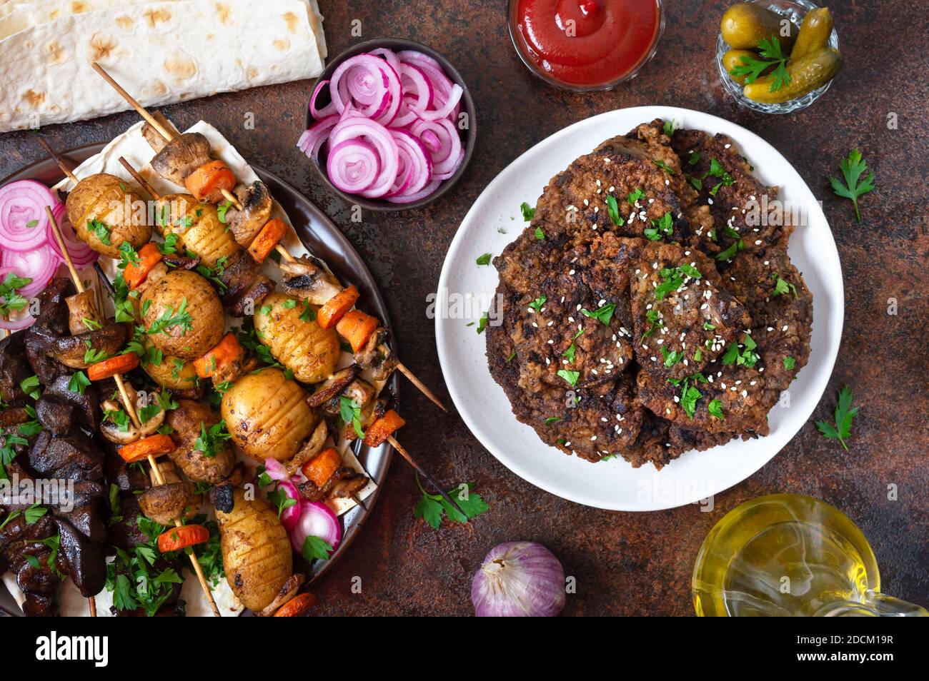Different dishes of liver kebab. Skewered liver, whole vegetables and ...