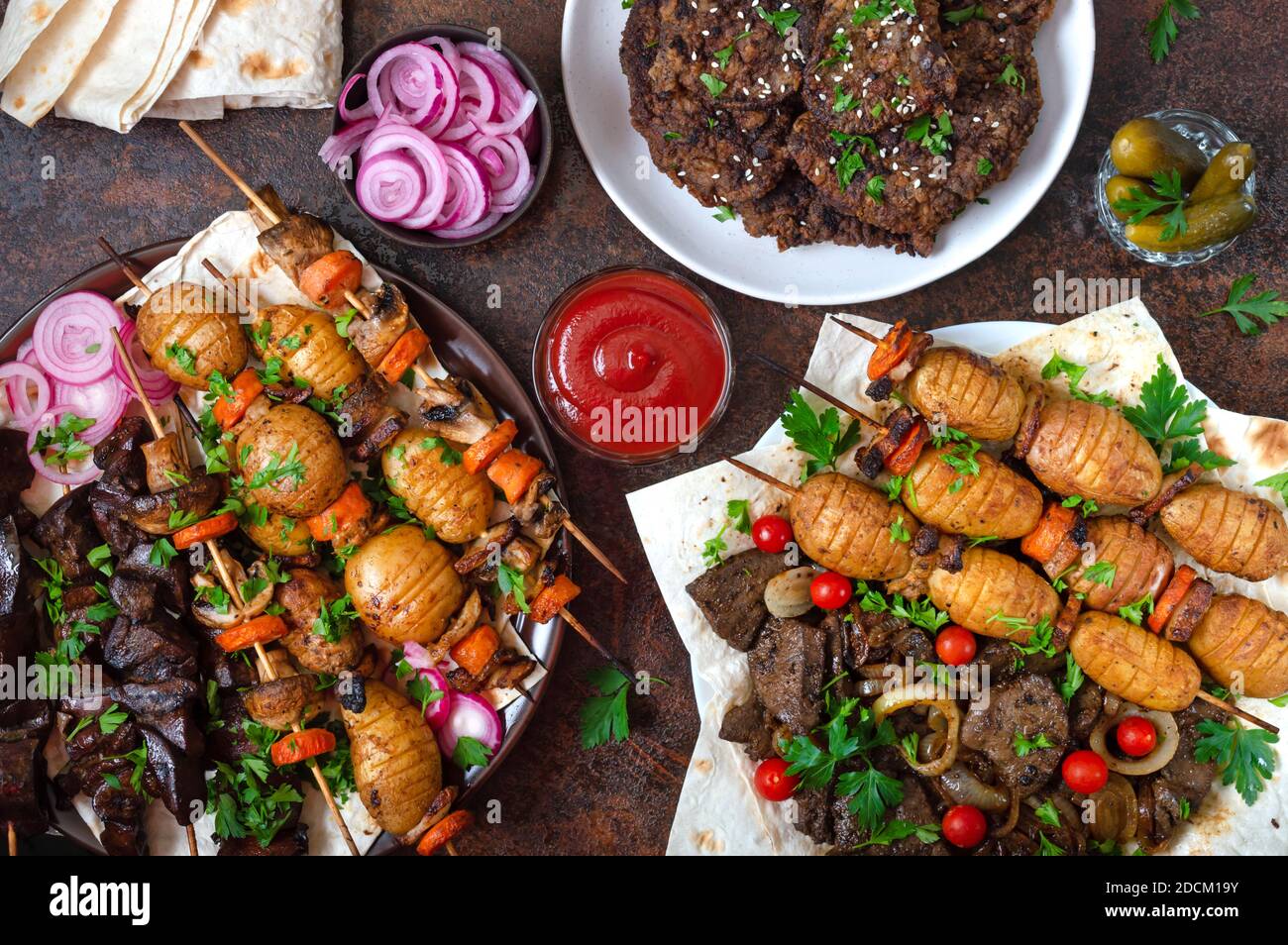 Different dishes of liver kebab. Skewered liver, whole vegetables and ...
