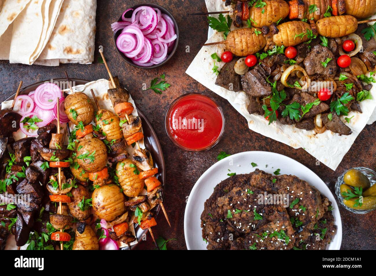 Different dishes of liver kebab. Skewered liver, whole vegetables and ...