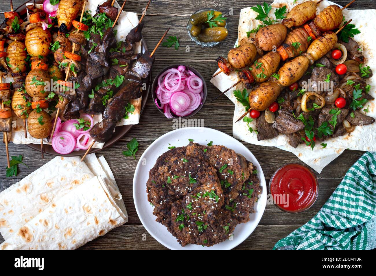 Different dishes of liver kebab. Skewered liver, whole vegetables and ...