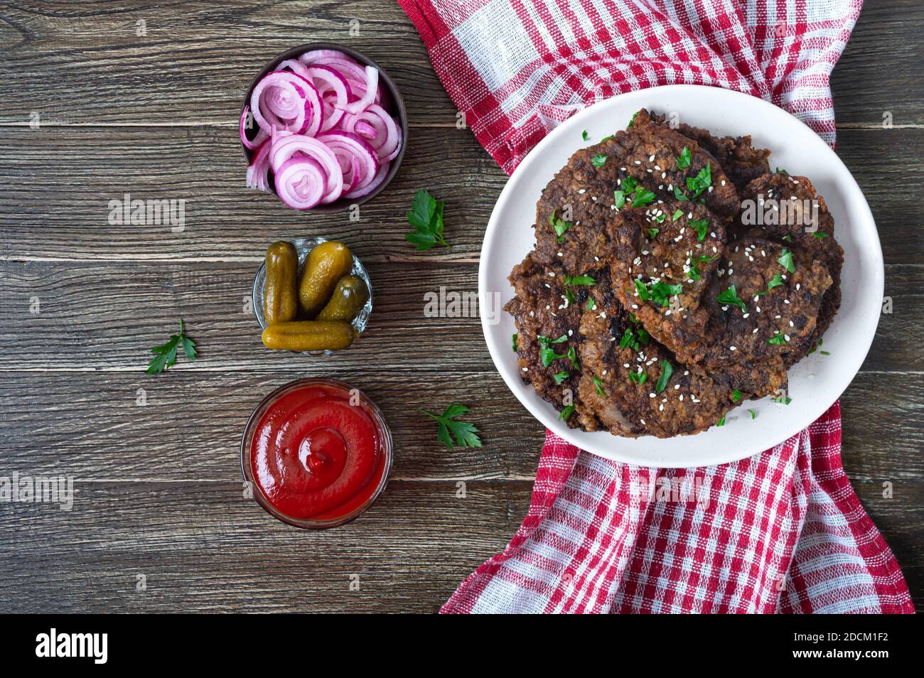 Fried liver pieces with tomato sauce, pickled onions and cucumbers ...