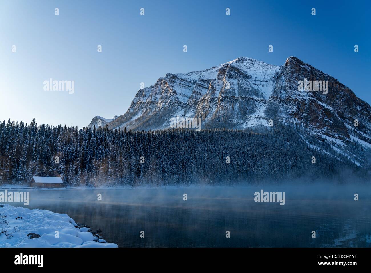 Lake Louise in early winter sunny day morning. Mist floating on ...