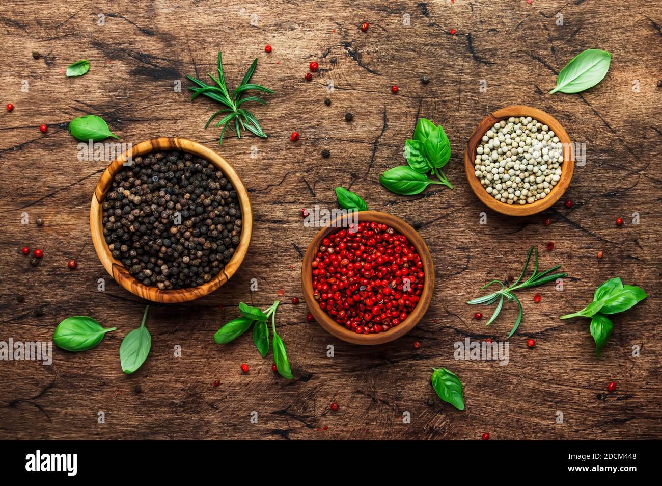 Black, white and pink rose peppers in bowls, assorted spices and spicy ...