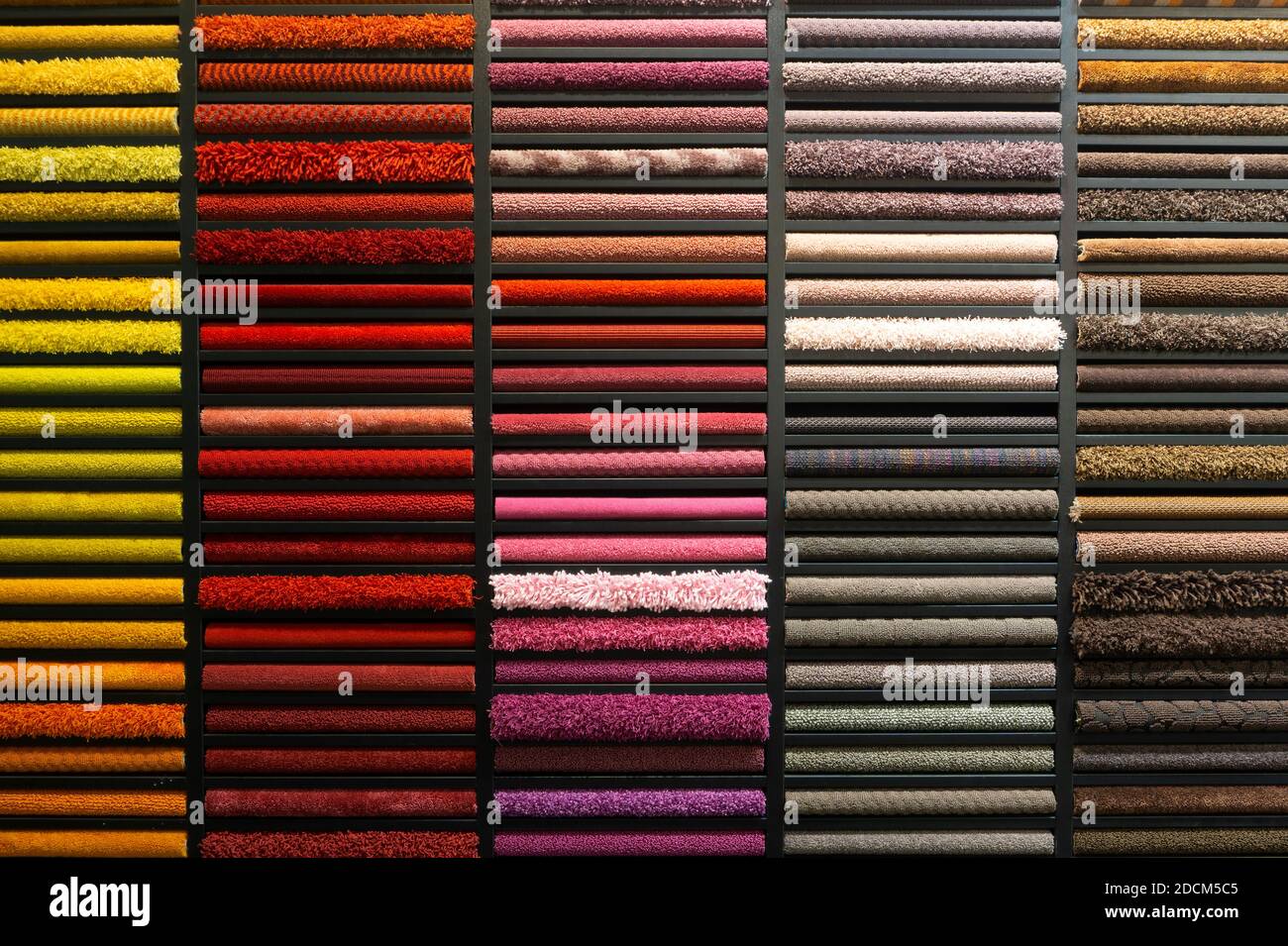 Samples of carpets of different colors on a stand in a store or ...