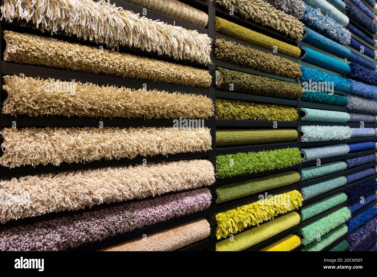 Samples of carpets of different colors on a stand in a store or ...