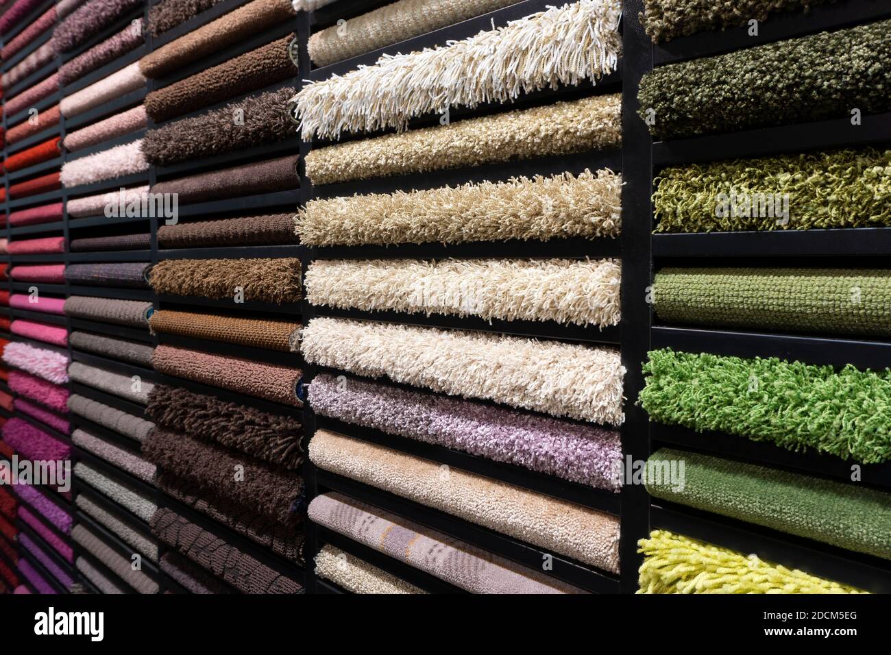 Samples of carpets of different colors on a stand in a store or ...