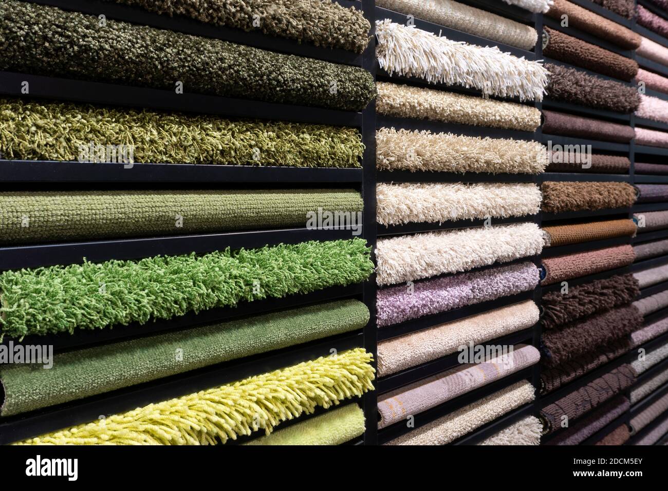 Samples of carpets of different colors on a stand in a store or ...