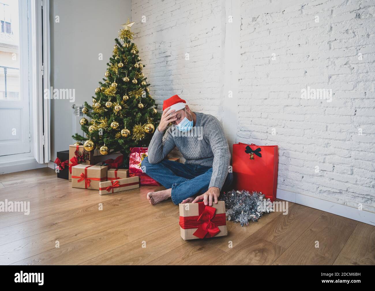 Sad man with mask home alone in self isolation at christmas feeling ...