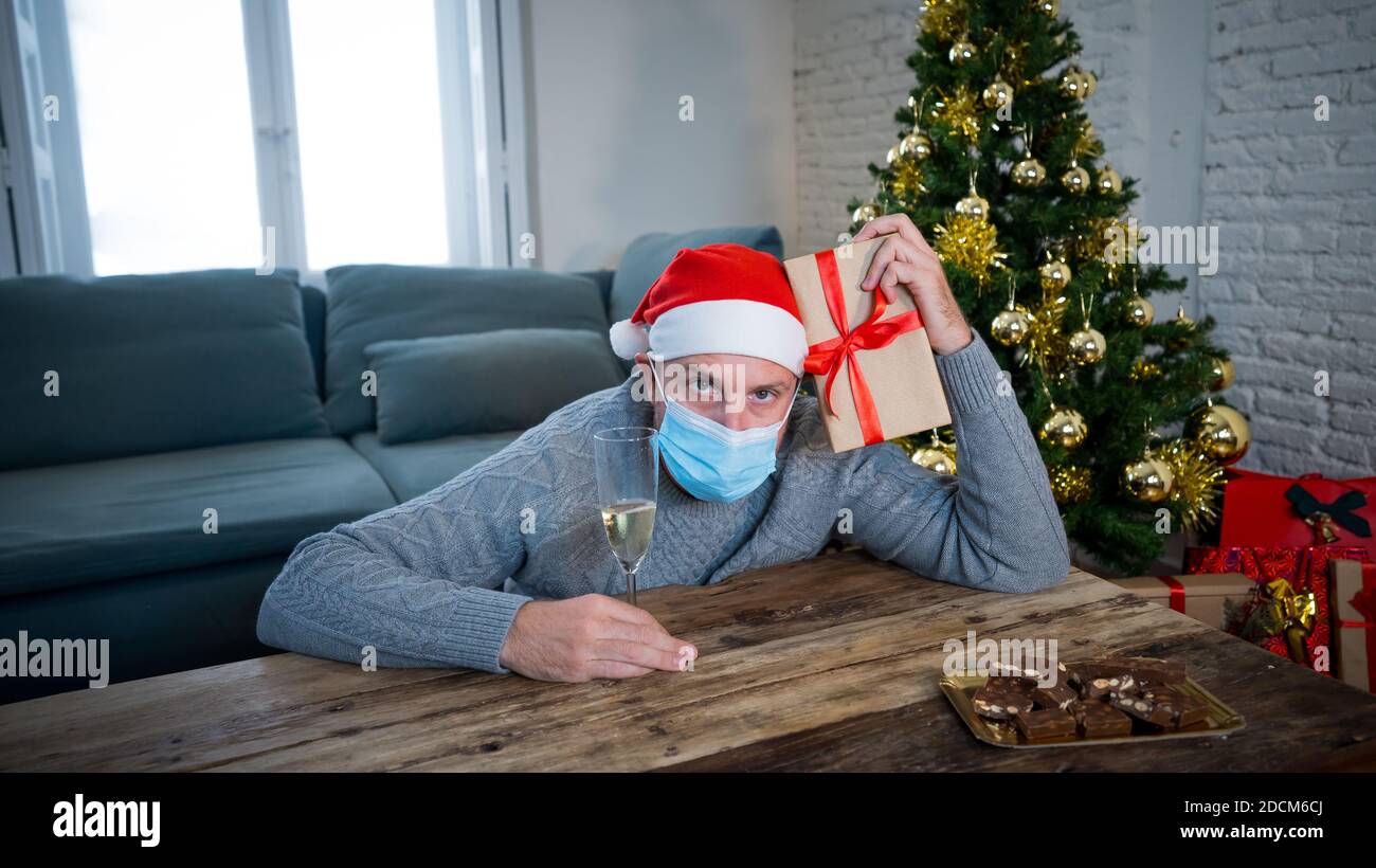 Sad man with mask home alone in self isolation at christmas feeling ...