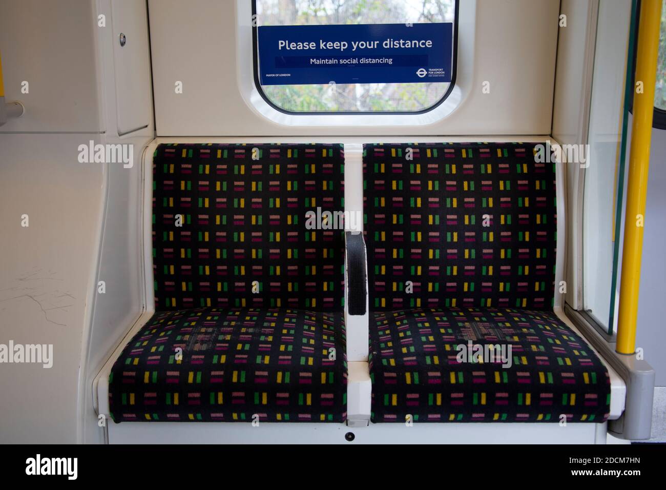 Two seats with a sign to request social distancing on a District Line ...