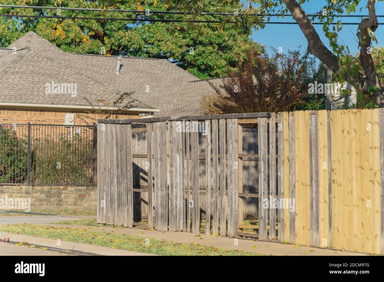 Collapsed aged wooden fence near new lumber boards installation at ...