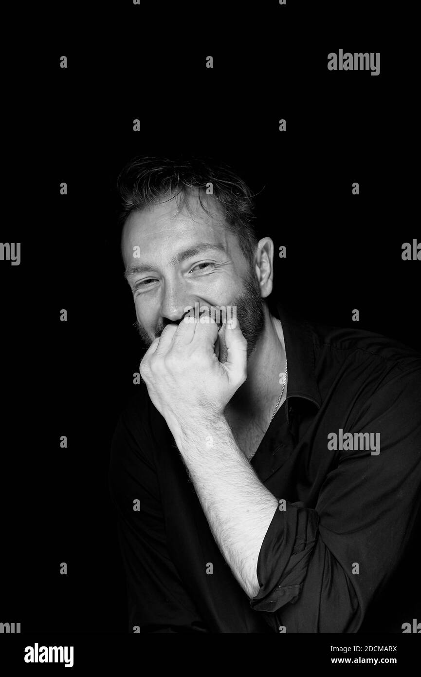 A man on a black background, satisfied with himself and life.Emotion of ...