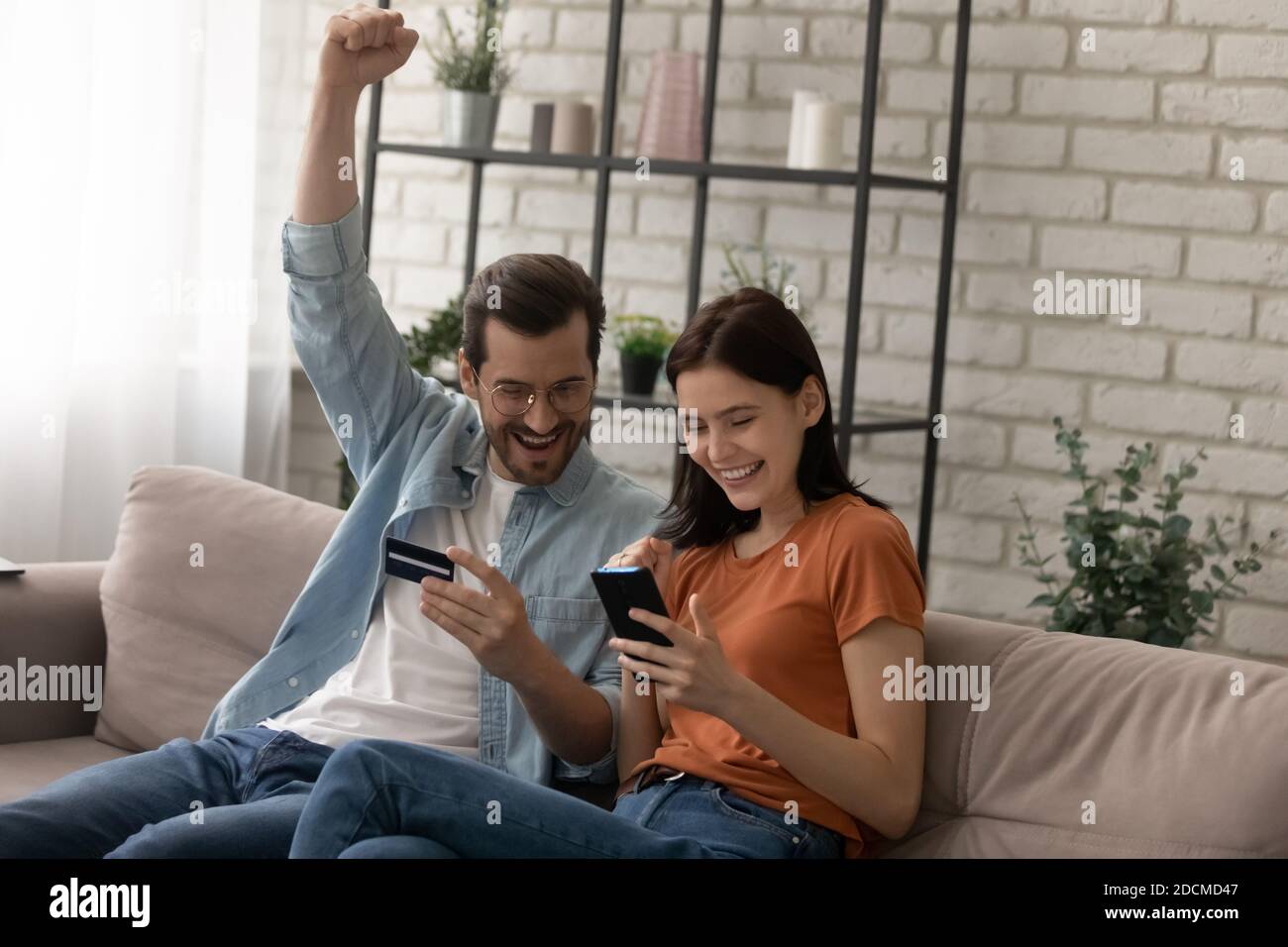 Happy young married family celebrating winning prize in giveaway Stock ...