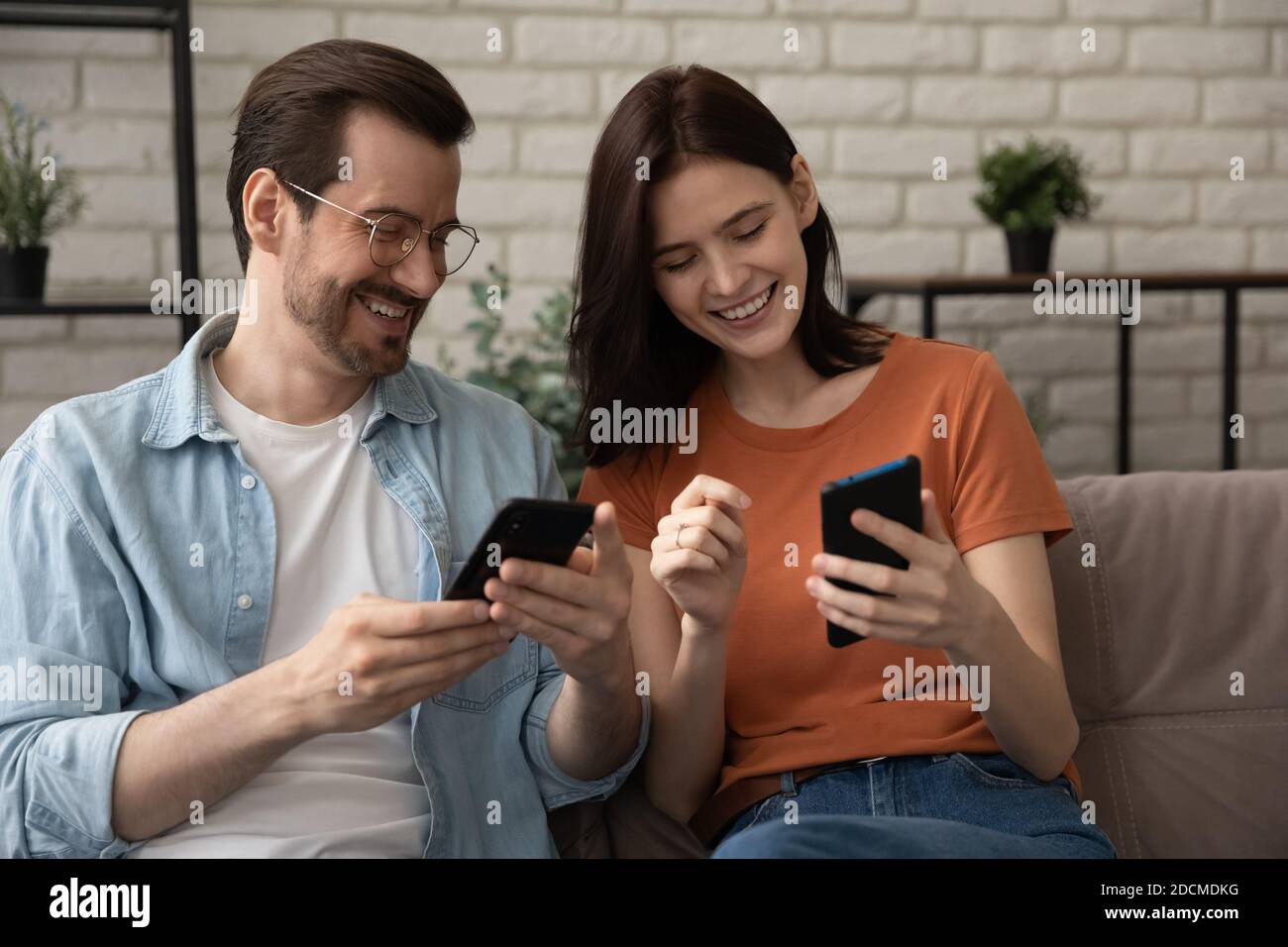 Happy caucasian young married family couple using smartphones Stock ...