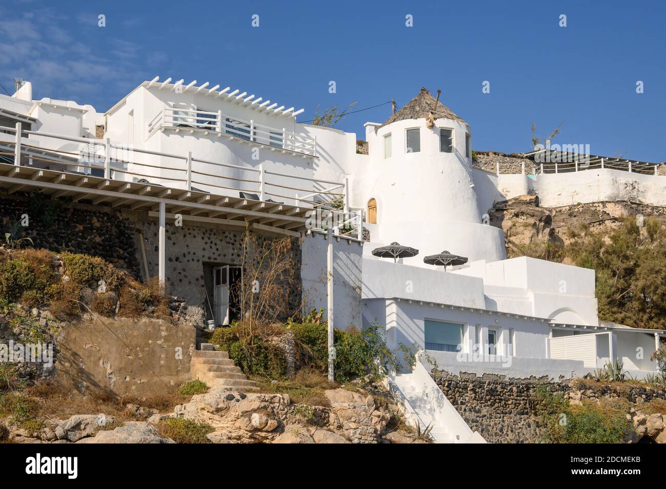 Whitewashed Greek houses on the cliff side at Vlychada harbor on the ...