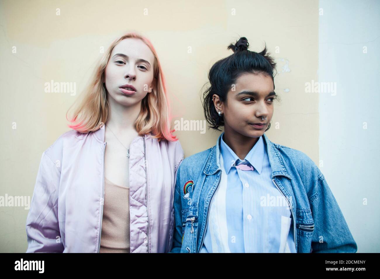 Two teenage girls infront of university building smiling, having fun ...