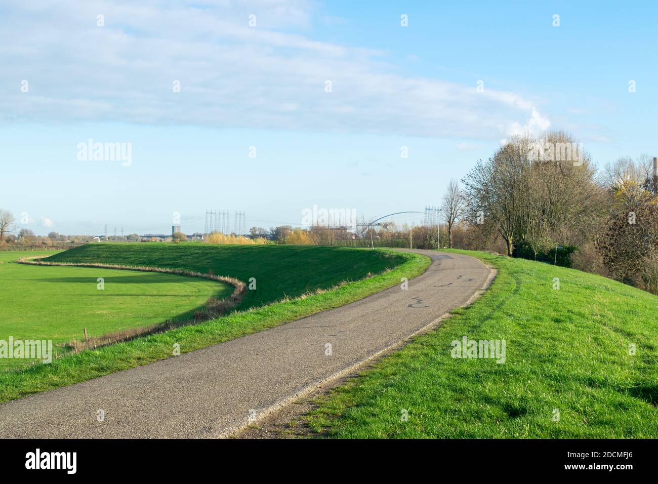 Dutch landscape with dike and small road under blue sky Stock Photo - Alamy