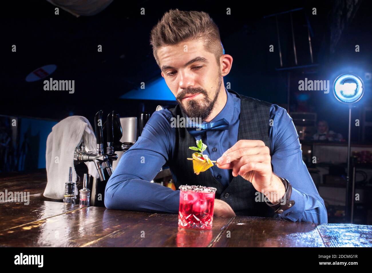 Young barman makes a cocktail at the bar counter Stock Photo - Alamy