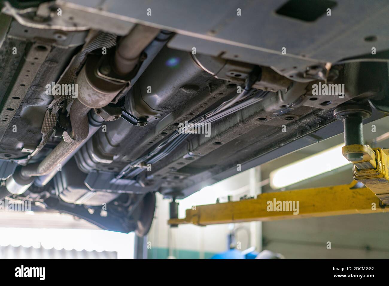 Car lifted in automobile service for fixing, worker repairs detail ...
