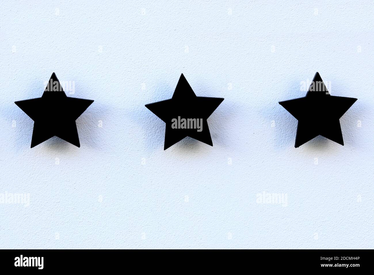 Three stars on a white facade - three stars hotel Stock Photo - Alamy
