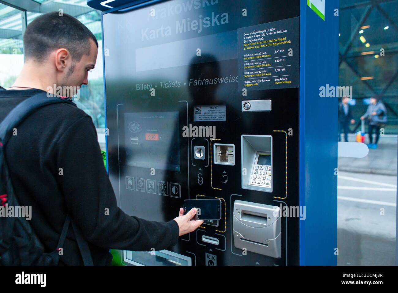 A tourist guy buys a bus ticket for the first time using an electronic ...