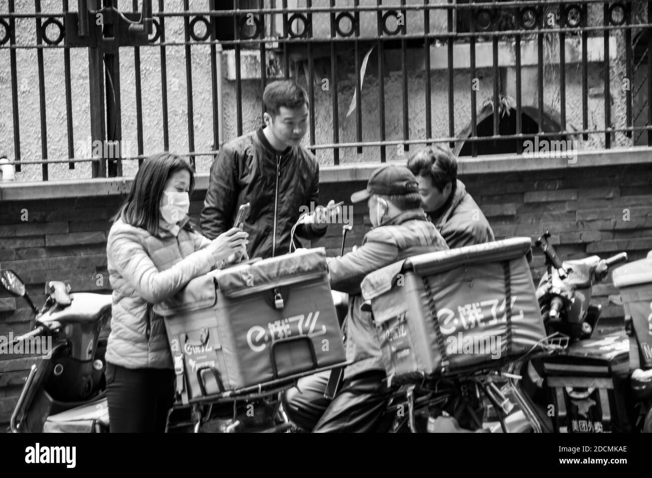 Food delivery drivers talking on Yuyuan East Road in Shanghai Stock ...