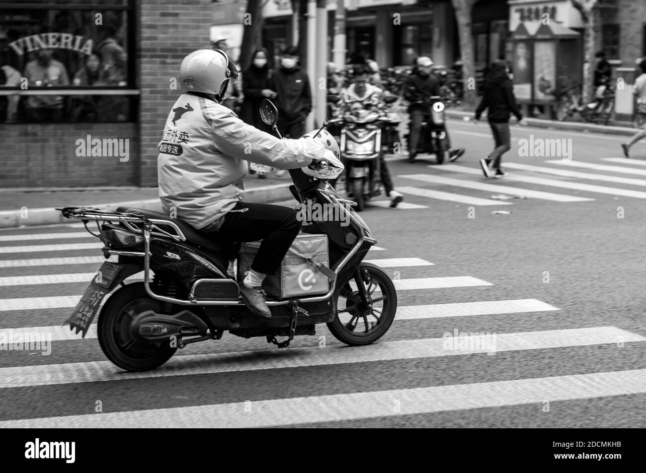 A Meituan delivery guy on a scooter with an Eleme delivery bag at the ...