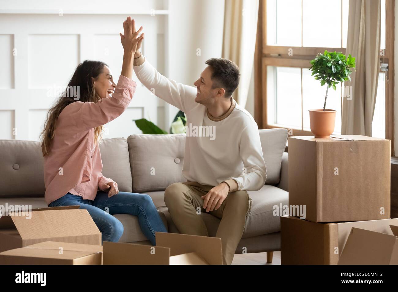 Couple giving high five celebrate move day to new house Stock Photo - Alamy