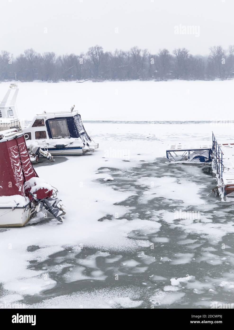 Small boats trapped in ice on frozen river Danube at -15C Stock Photo ...