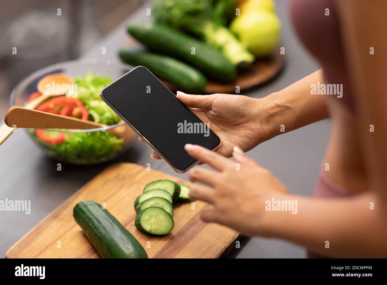 Woman Using Mobile Phone With Empty Screen In Kitchen, Cropped Stock ...