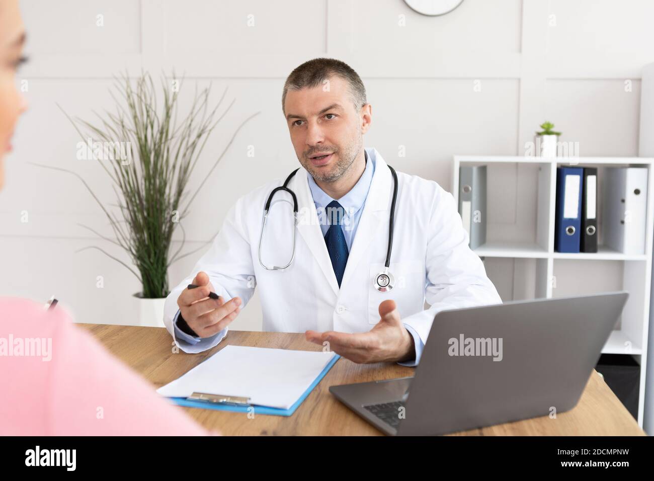Serious experienced doctor talking to his patient Stock Photo - Alamy