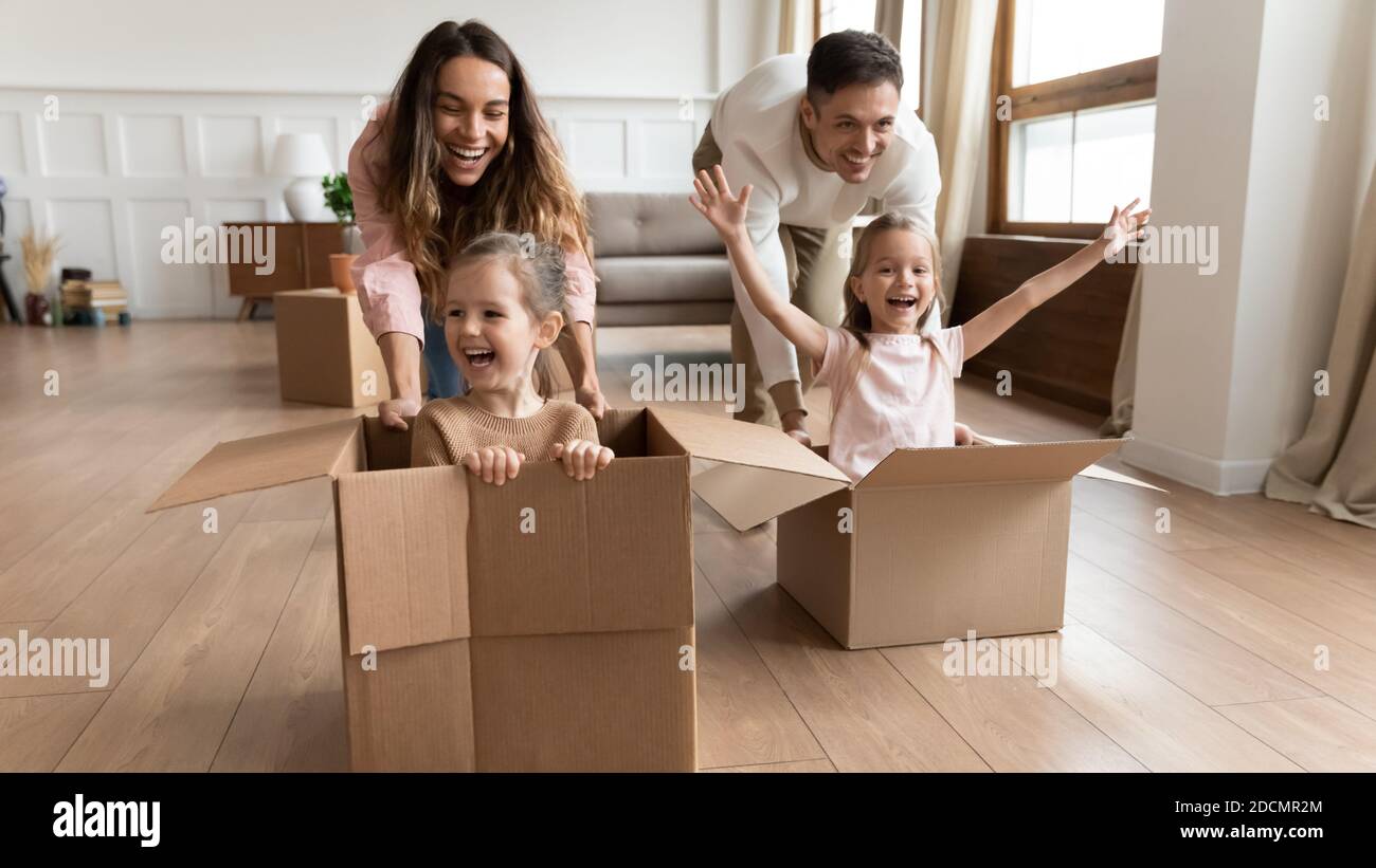 Cheerful girls sit inside of boxes during race competition Stock Photo ...