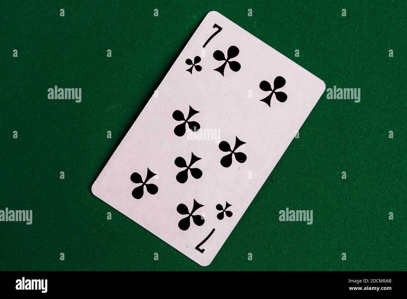 Seven of Club playing card, green background Stock Photo - Alamy