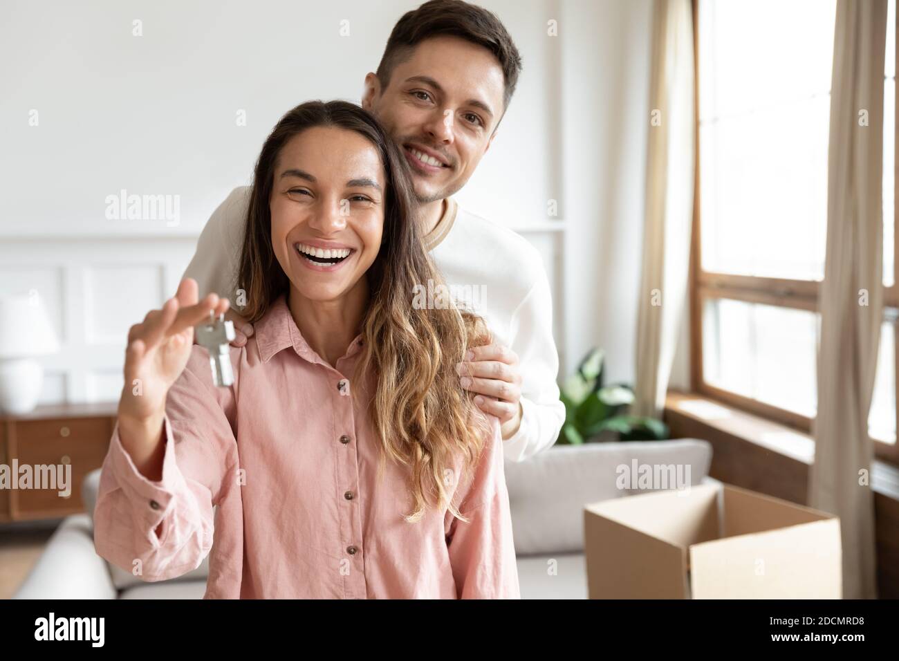 Happy husband hug wife holding keys to the new house Stock Photo - Alamy