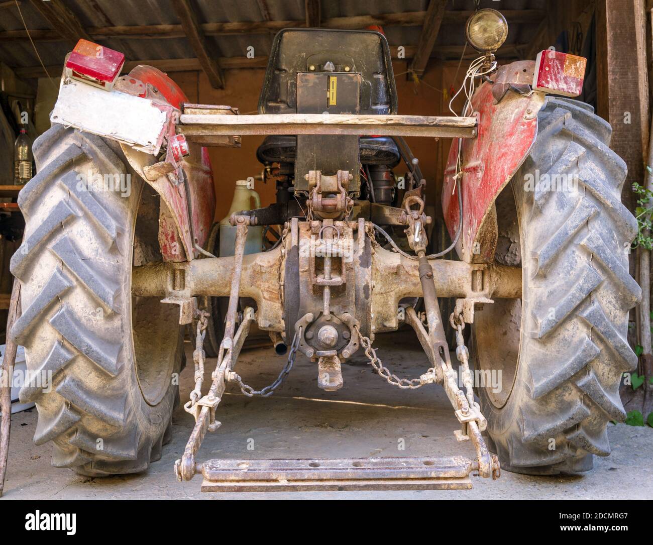 Red old farming tractor in garage Stock Photo - Alamy