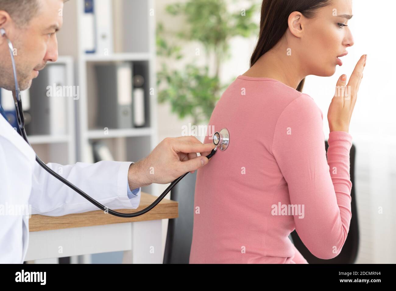 Male doctor checking breath of female patient Stock Photo - Alamy