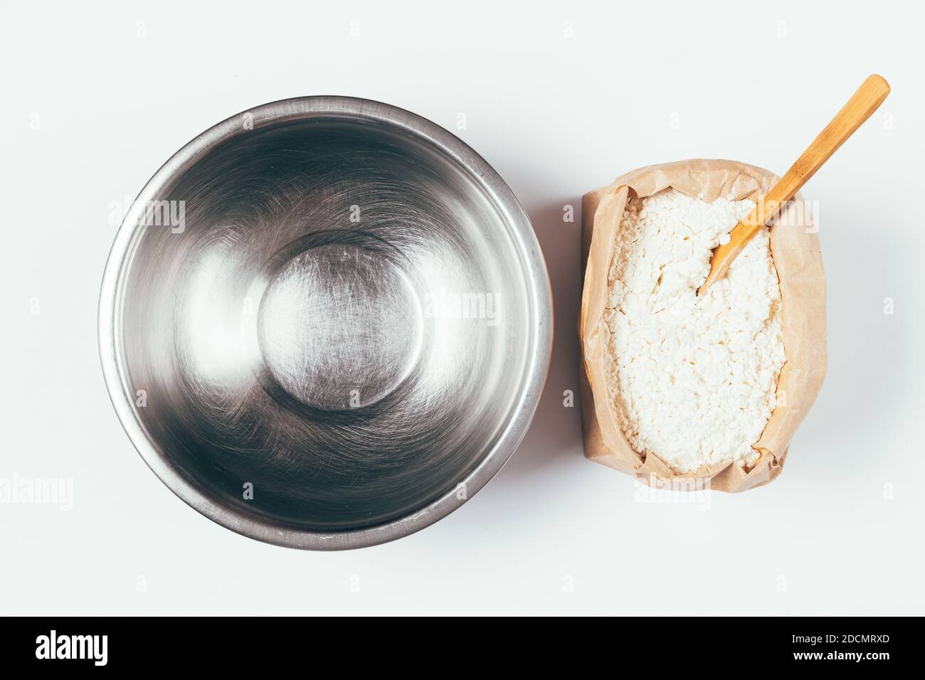 Empty metal bowl and pack of flour with wooden spoon, minimal cooking ...