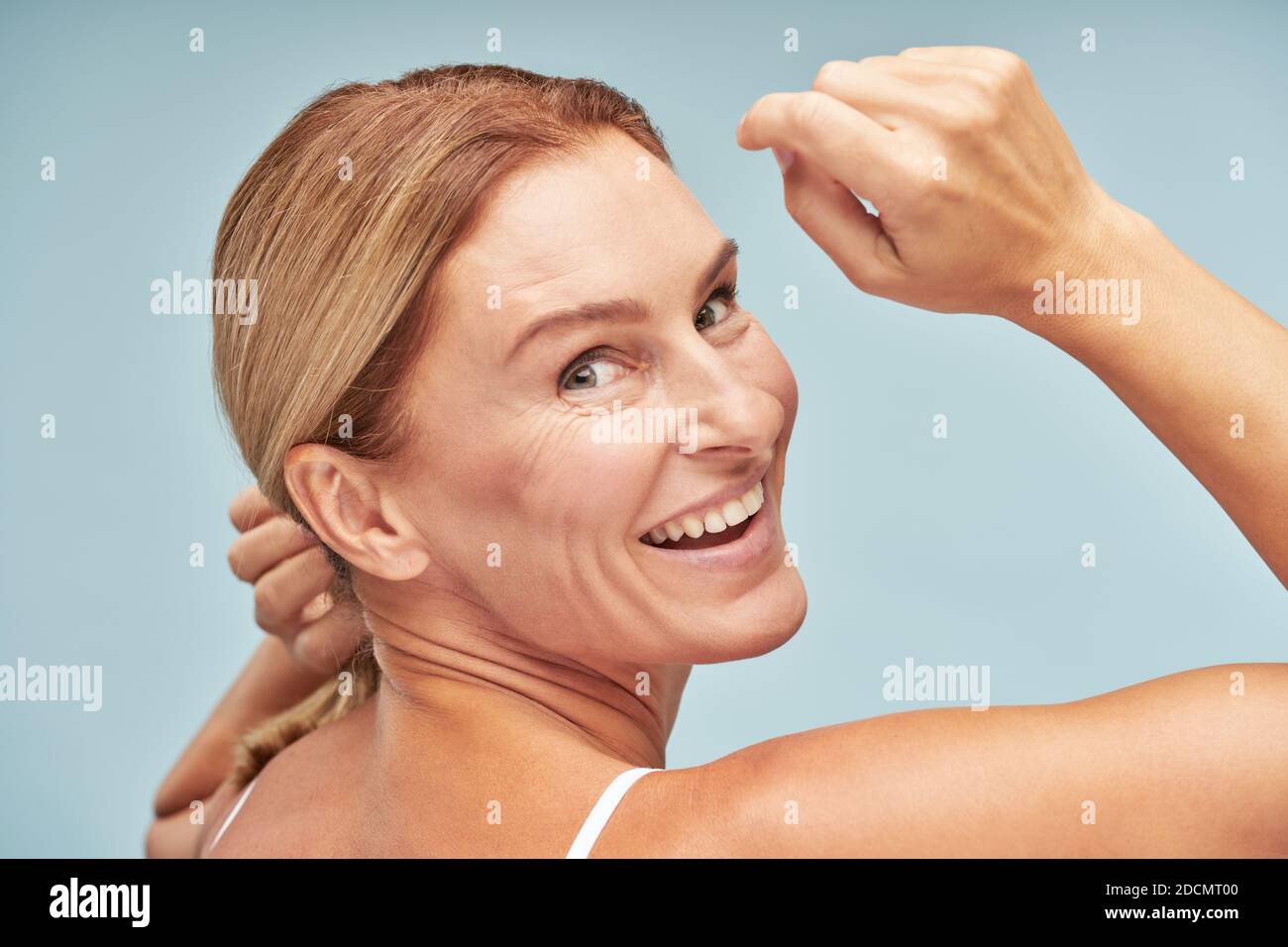 Happy caucasian woman looking back and posing at camera while standing ...