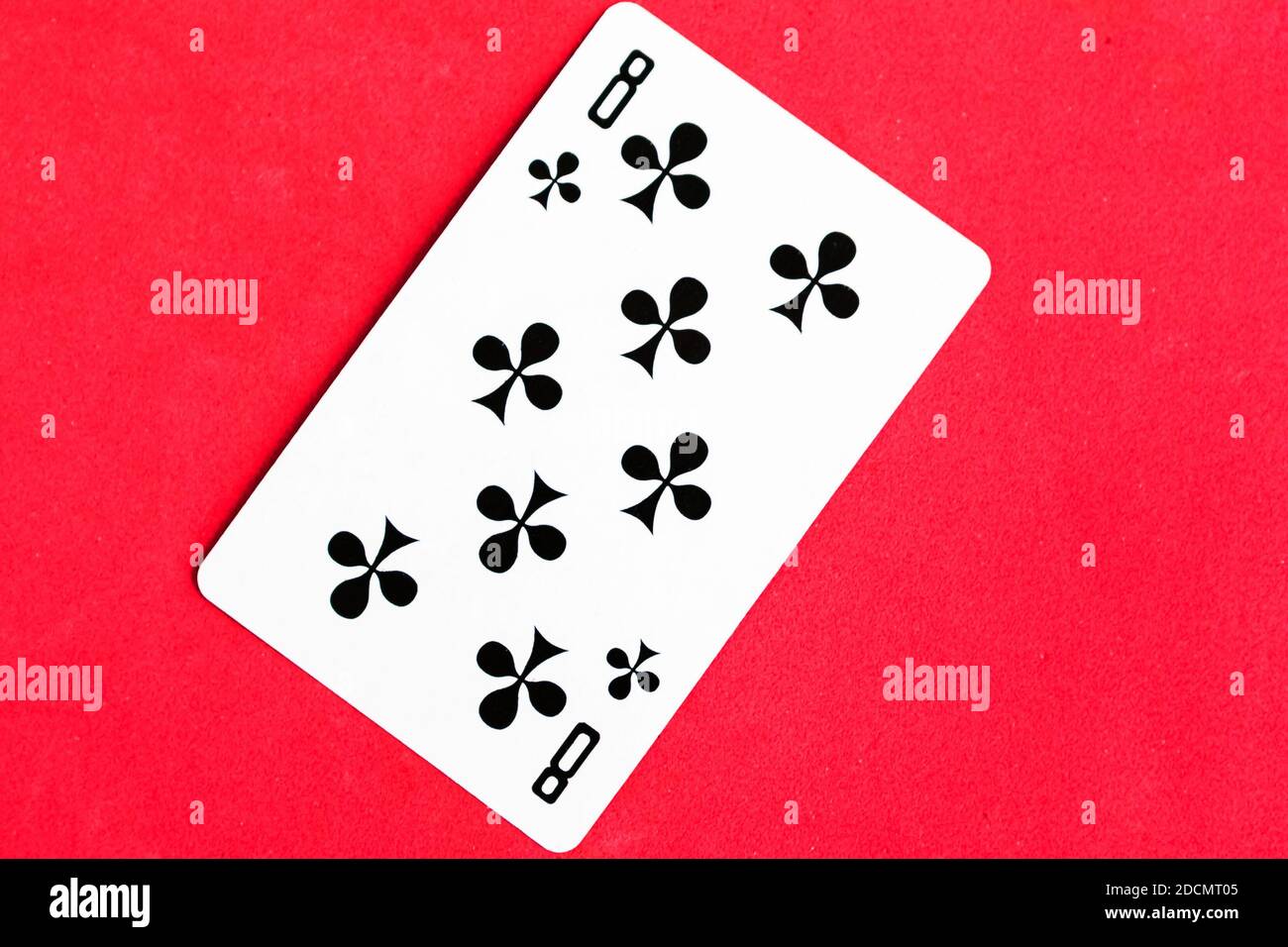 Eight of Clubs playing card, red background Stock Photo - Alamy