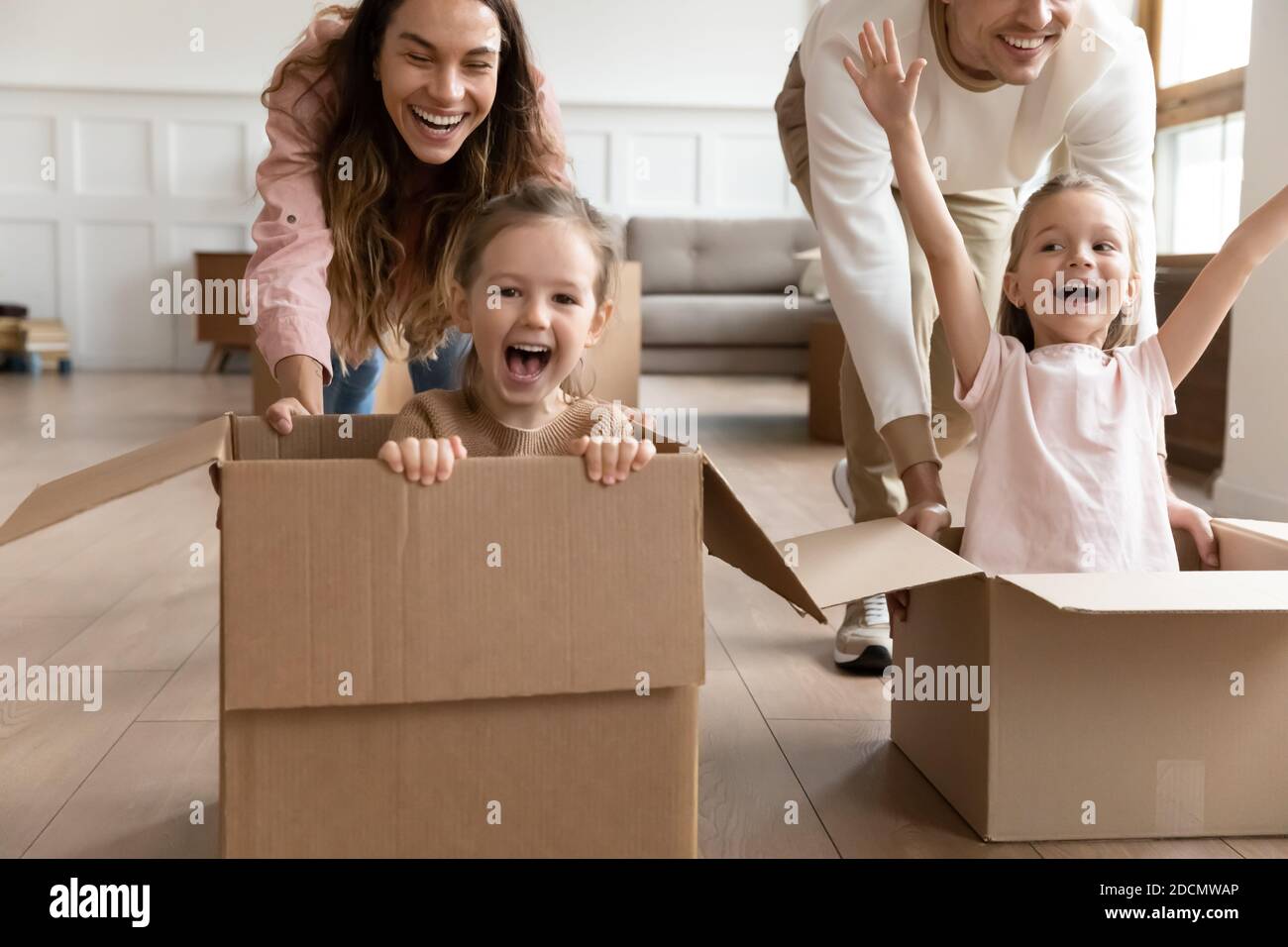 Parents push daughters sitting inside of boxes compete in races Stock ...
