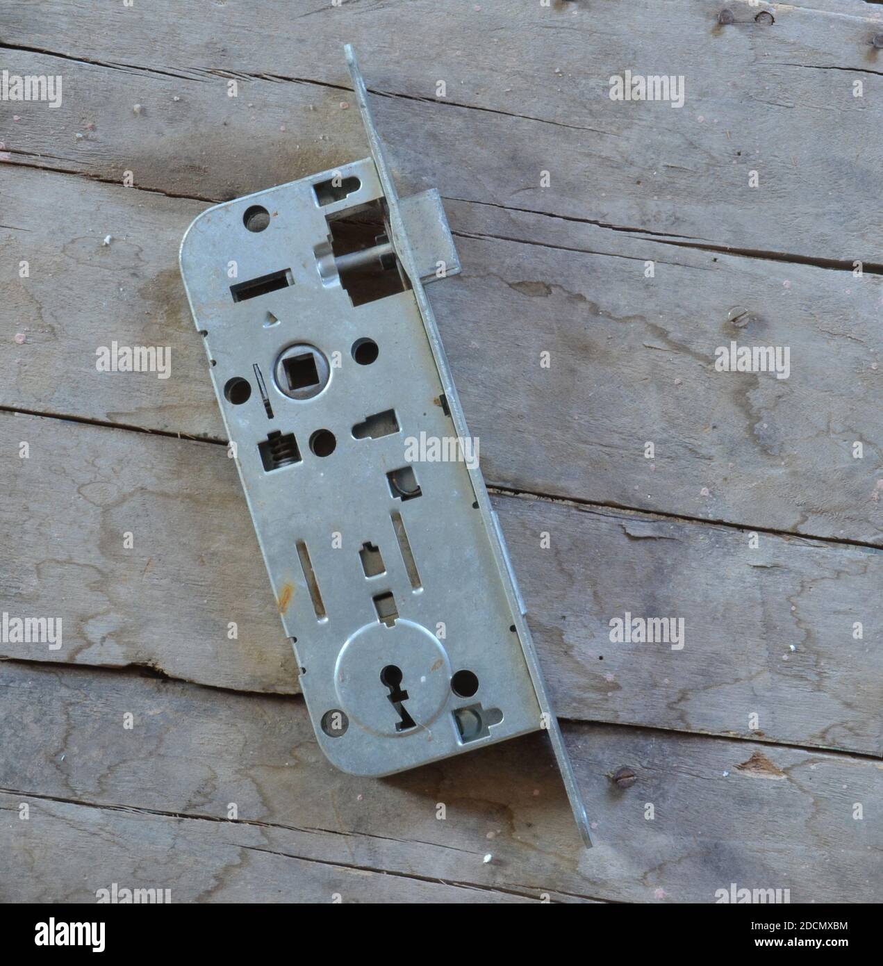 Vintage metal mechanism for door lock on wooden surface Stock Photo - Alamy