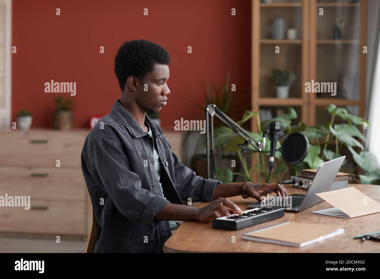 Side view portrait of young African-American man composing music in ...