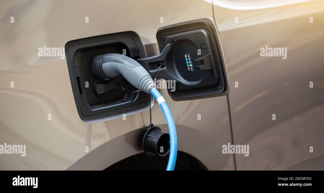 Close-up of an electric car with connected cable Stock Photo - Alamy