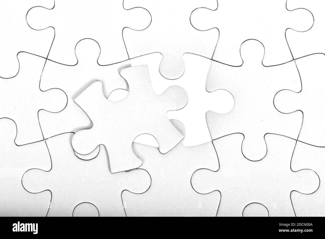 White jigsaw puzzle pattern background. placing last piece of jigsaw ...