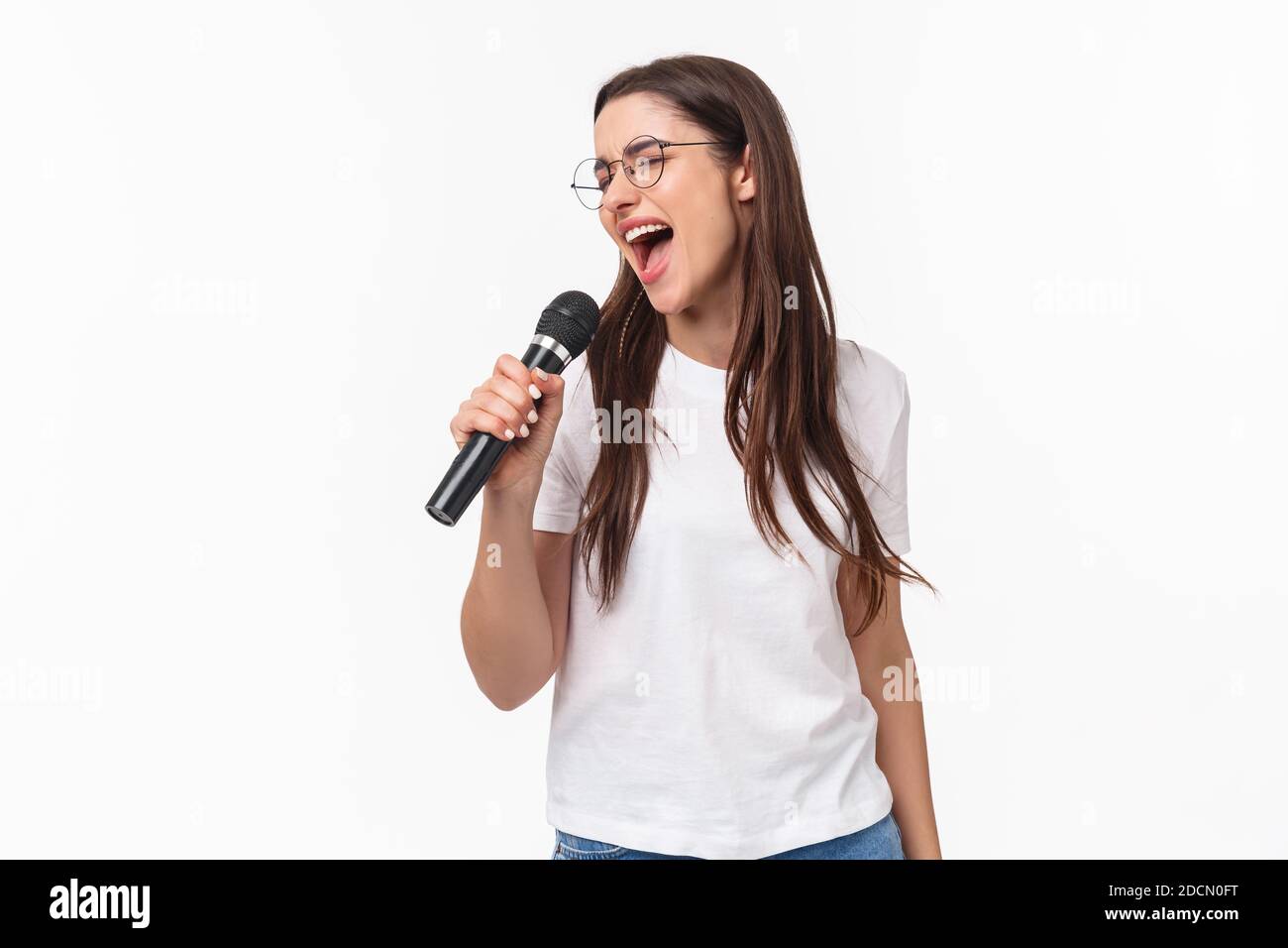 Carefree happy and relaxed young woman singing her heart out ...
