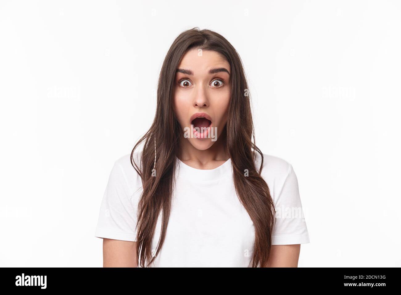Close-up portrait of surprised and startled young brunette female drop ...