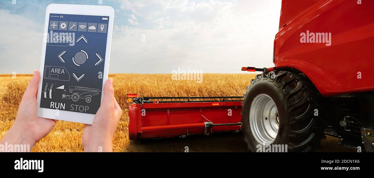 Farmer uses a digital tablet to control autonomous harvester. Smart ...