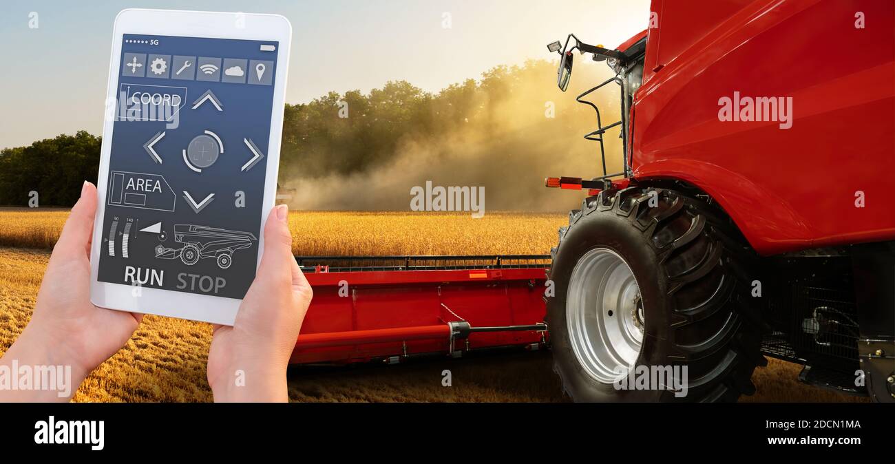Farmer uses a digital tablet to control autonomous harvester. Smart ...
