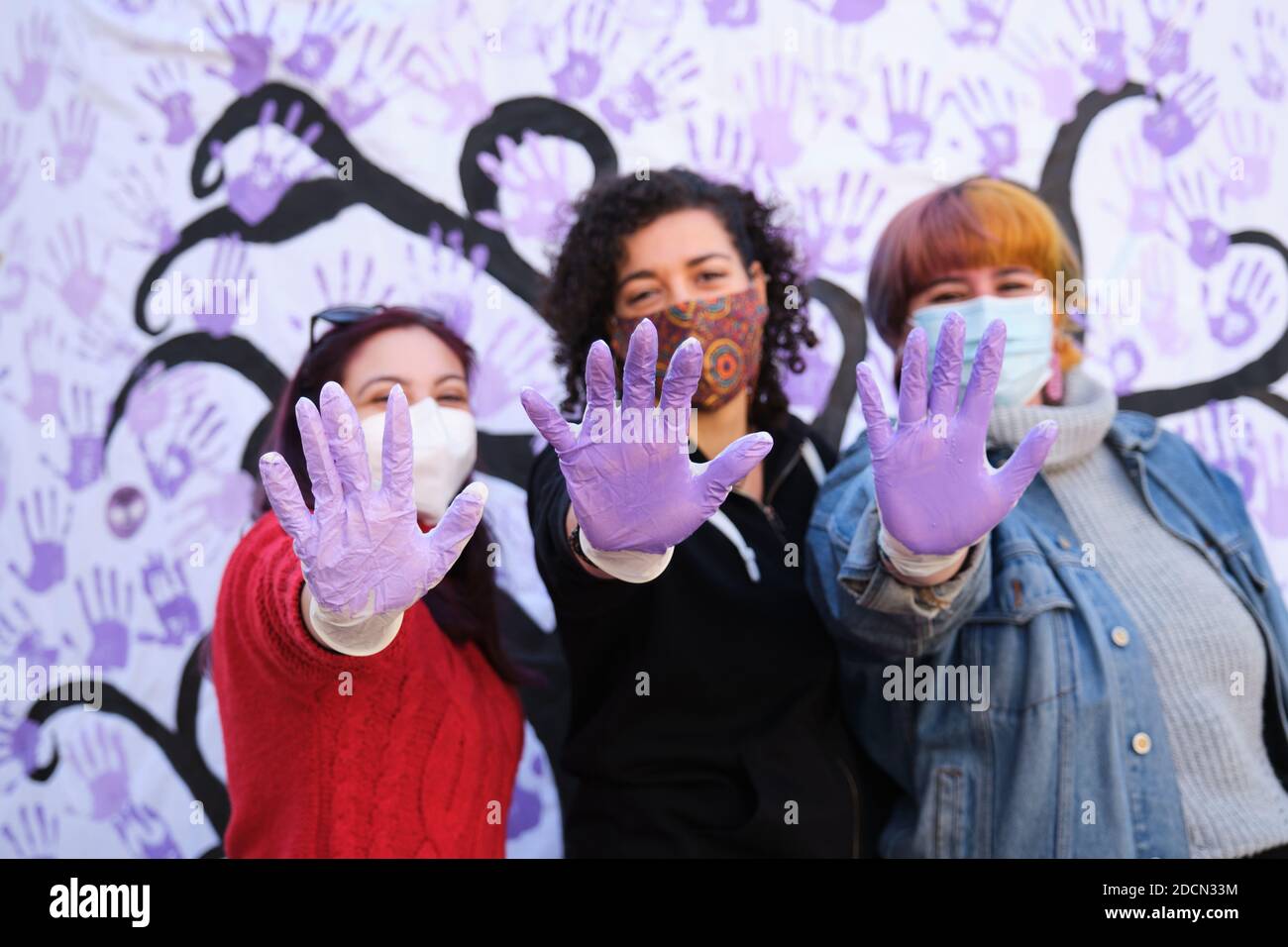 Three women with their hands painted purple participating in the ...